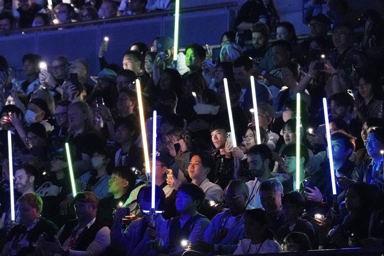 'Star Wars' fans wave lightsabers as an upcoming film gets announced in Japan