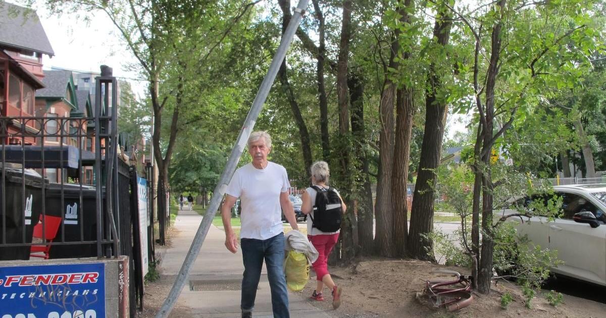 Leaning sign post is a head-bumping obstacle
