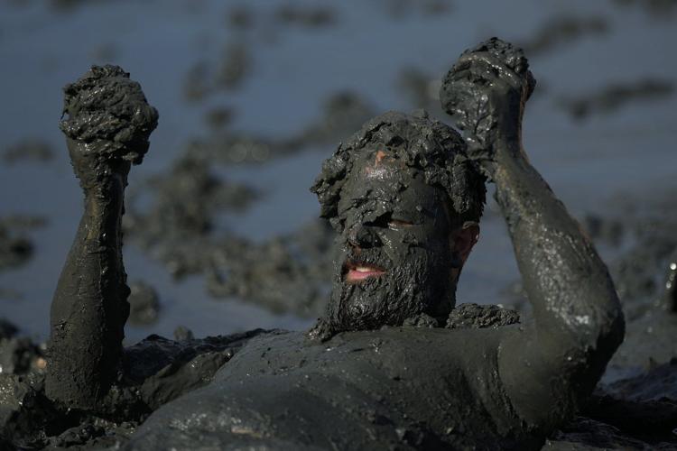 Mud-covered Carnival revelers are a strange sight in sleepy Brazilian town