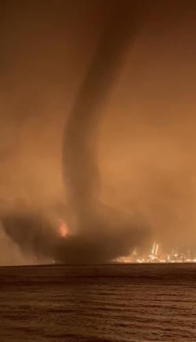 Video captures 'incredibly rare' B.C. wildfire tornado over lake