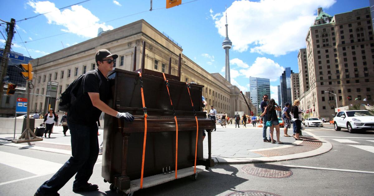 Muscular busker Sebastian Brown pushes a piano two kilometres to play