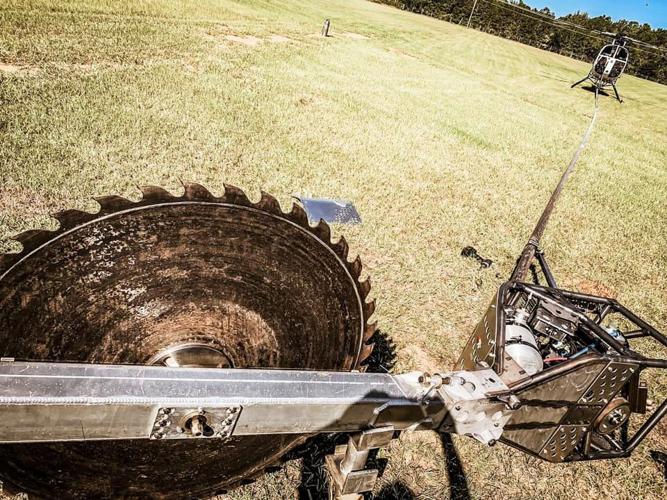 Low-flying helicopter trimming trees in region; 10 blades help clearing ...