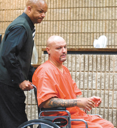 Murder suspect wheeled into court