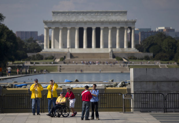 Veterans from Iowa, Mississippi pass barriers at closed WWII Memorial