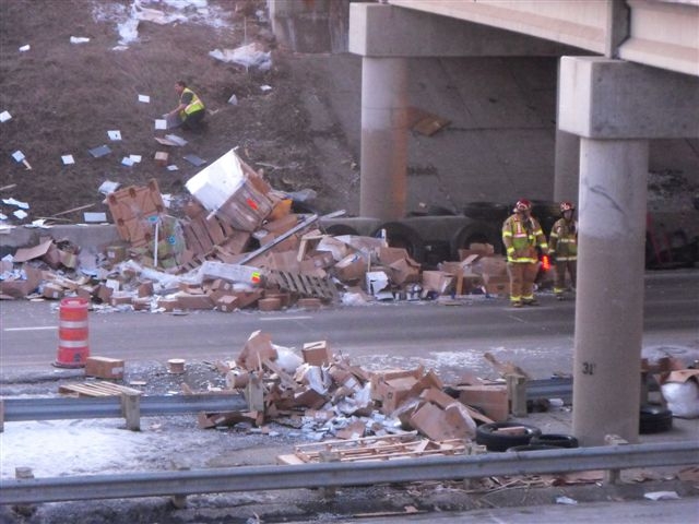 Tractor-trailer tips over, littering highway below