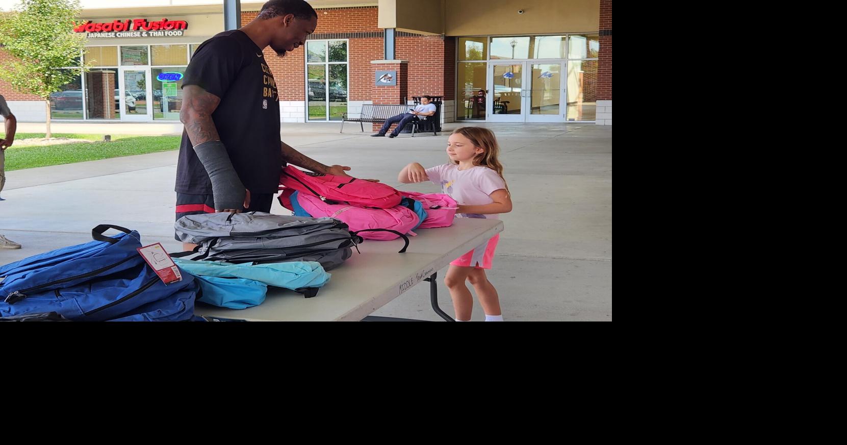 Former WVU basketball forward Gabe Osabuohien hads out free backpacks ...