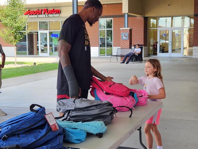 Former WVU basketball forward Gabe Osabuohien hads out free backpacks ...